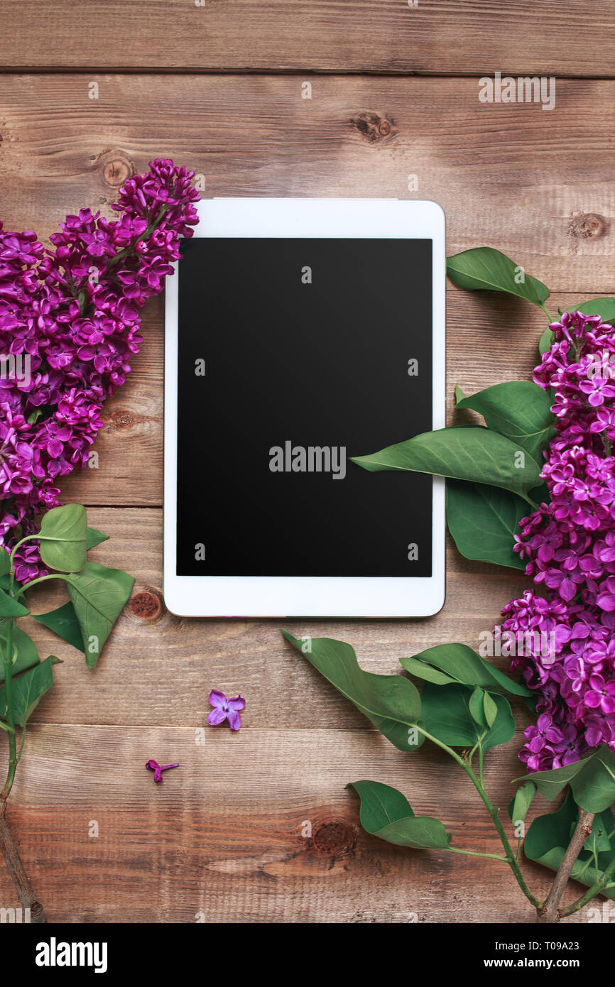 Bouquet of lilac flowers on wooden table with tablet. Top view Stock ...
