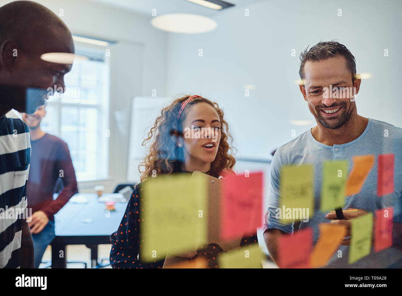 Diverse group of smiling young designers brainstorming together with ...