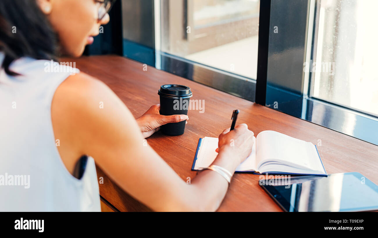 Young entrepreneur taking notes in cafe Stock Photo - Alamy