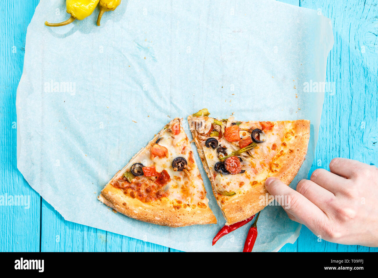 Image of pizza on table. Man take slice Stock Photo - Alamy