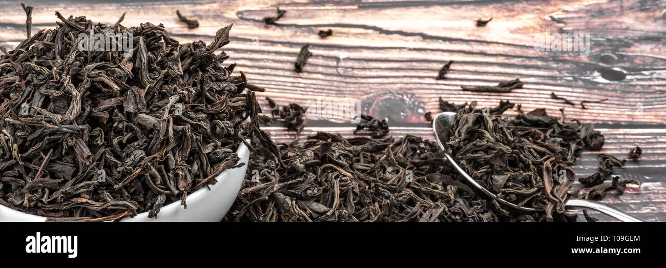 Dried tea is poured into a ceramic cup on a wooden plank table Stock ...