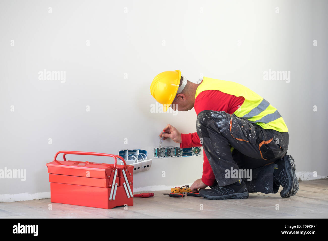 Electrician repairing / fixing wires in the wall Stock Photo - Alamy