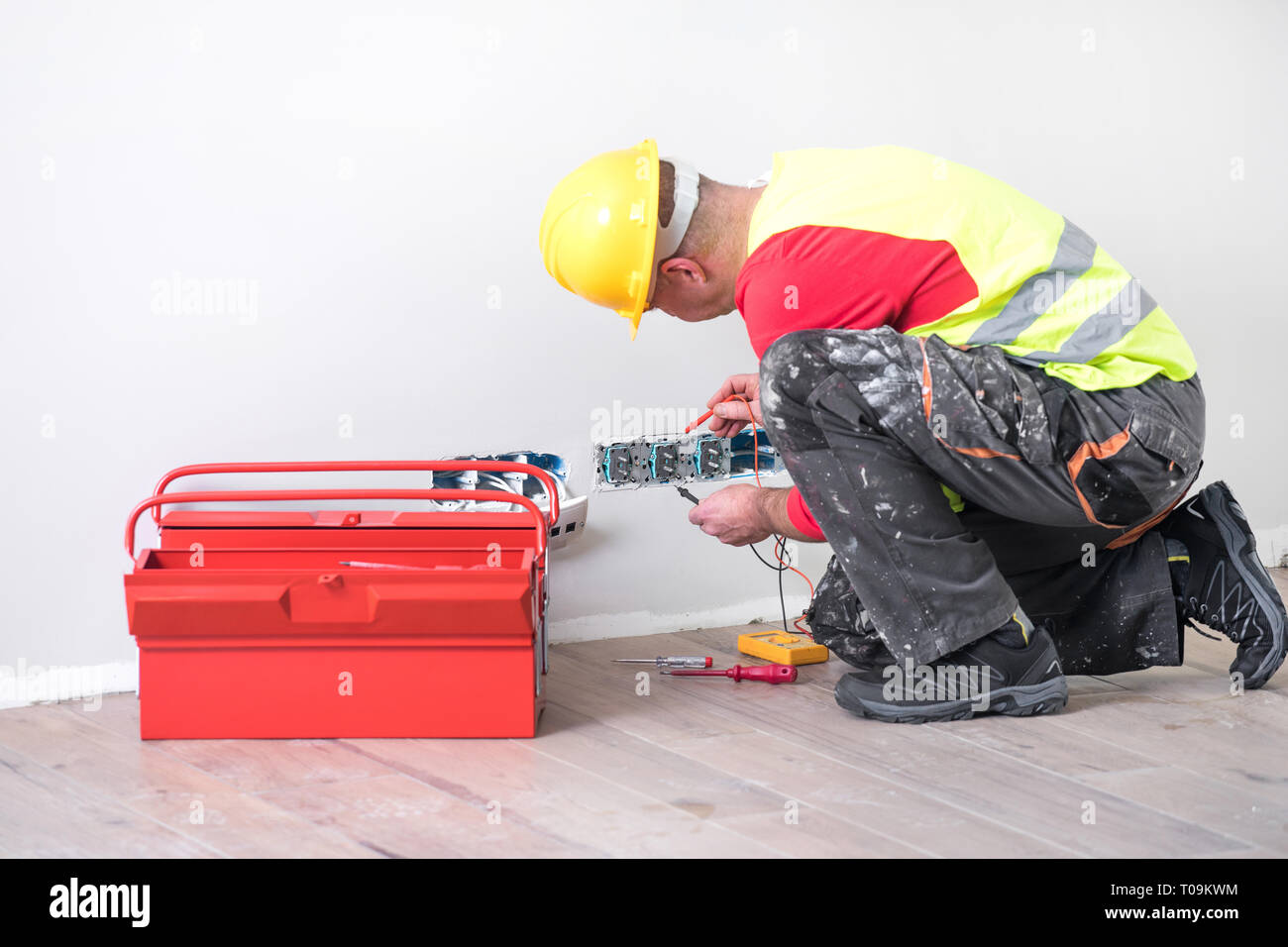 Electrician repairing / fixing wires in the wall Stock Photo - Alamy