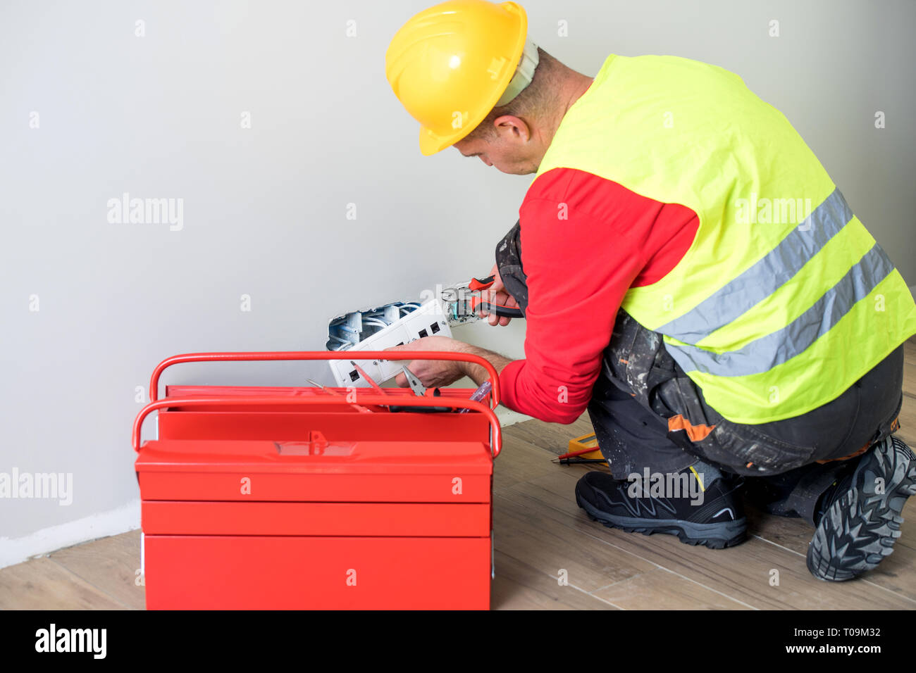 Electrician repairing / fixing wires in the wall Stock Photo - Alamy