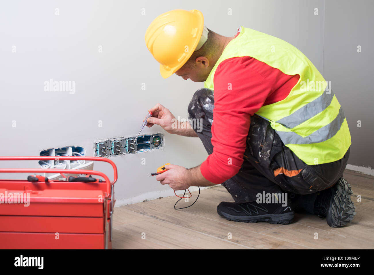 Electrician repairing / fixing wires in the wall Stock Photo - Alamy