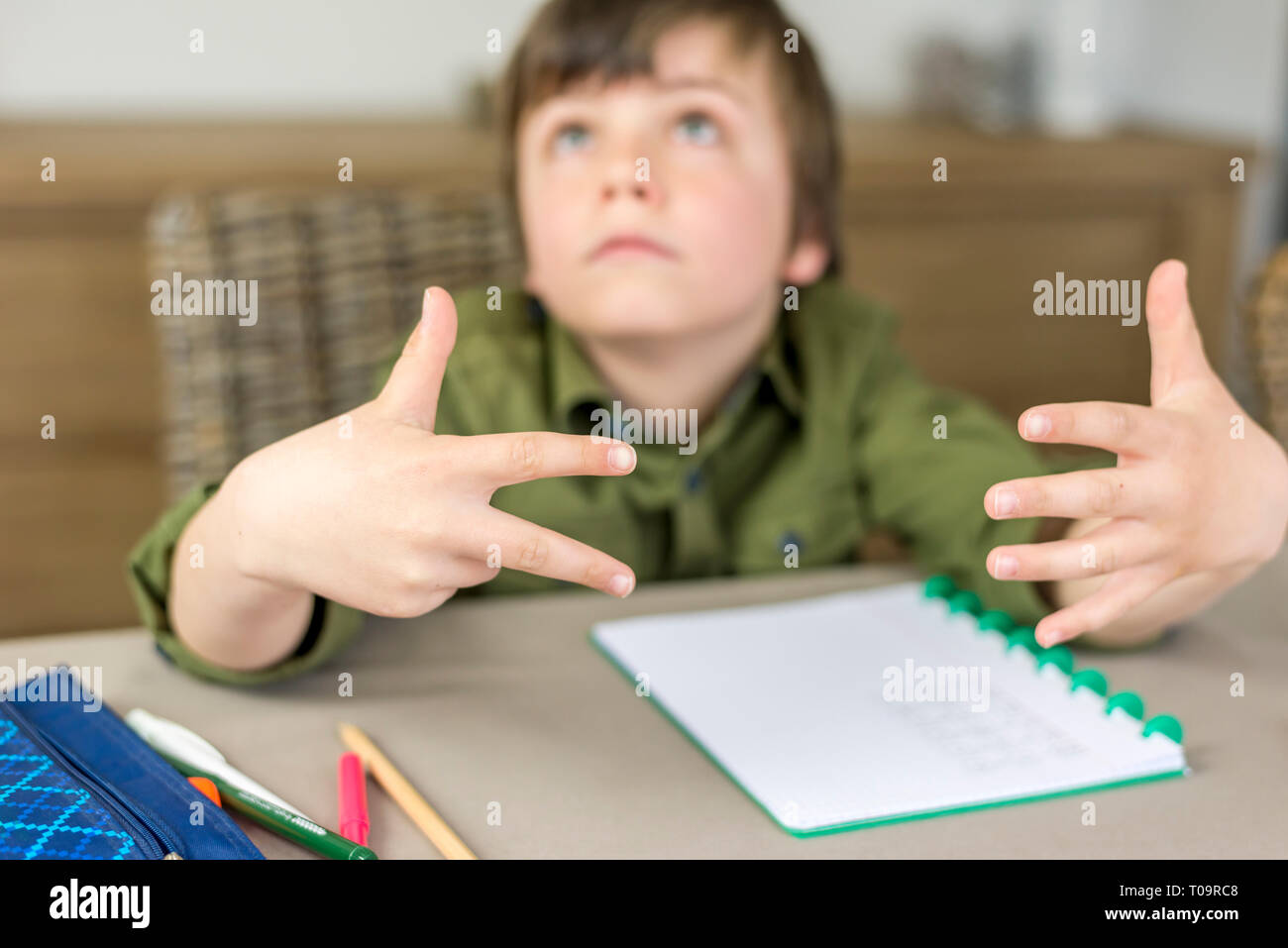 boy making homework, counting on his fingers. shallow depth of field ...