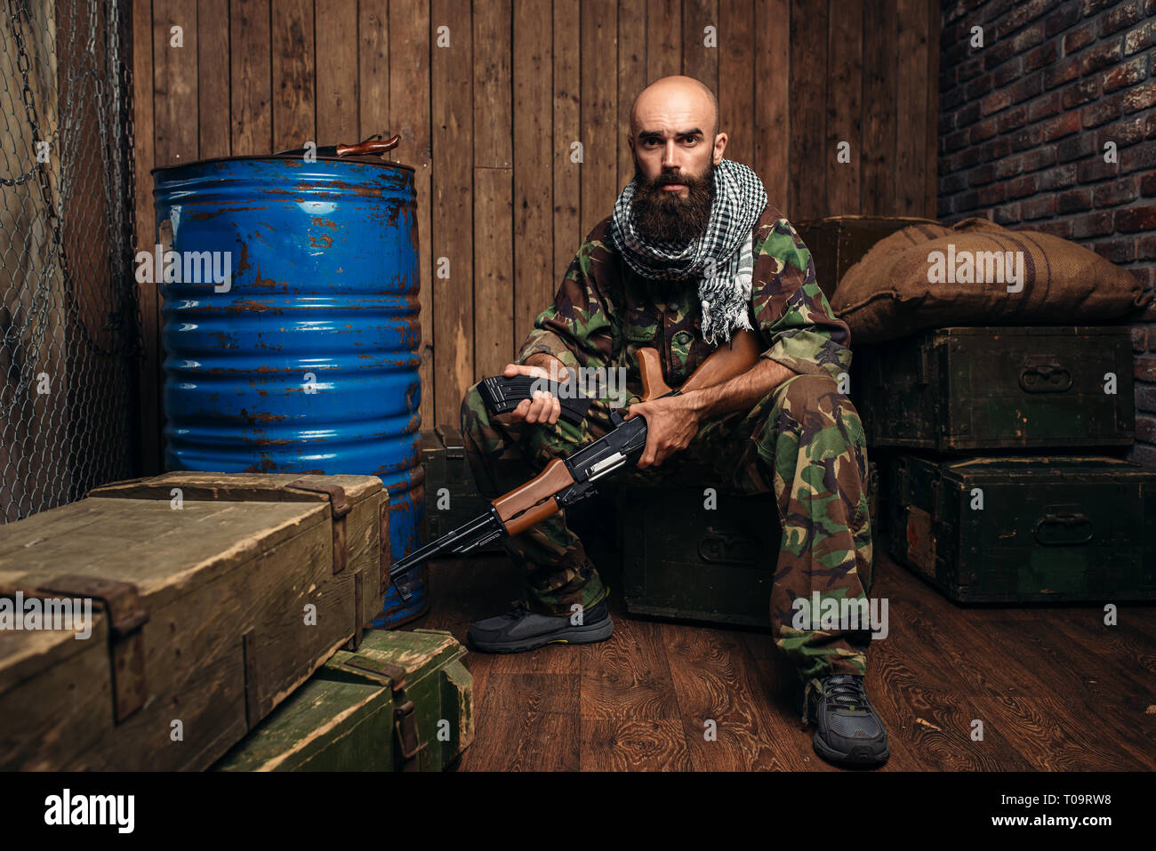 Terrorist in uniform inserts the magazine into the kalashnikov rifle ...