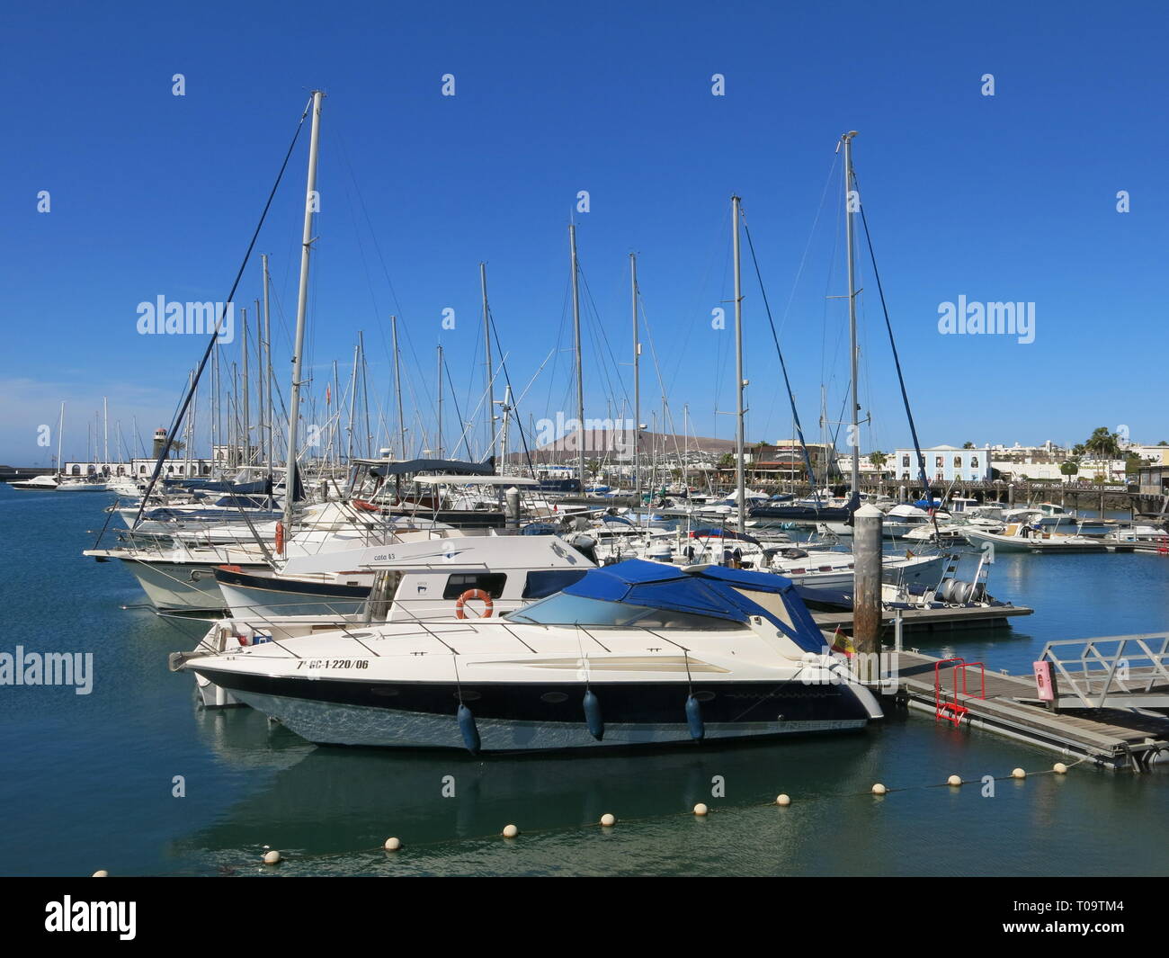 View of boats moored at Rubicon Marina; gleaming white yachts and tall ...