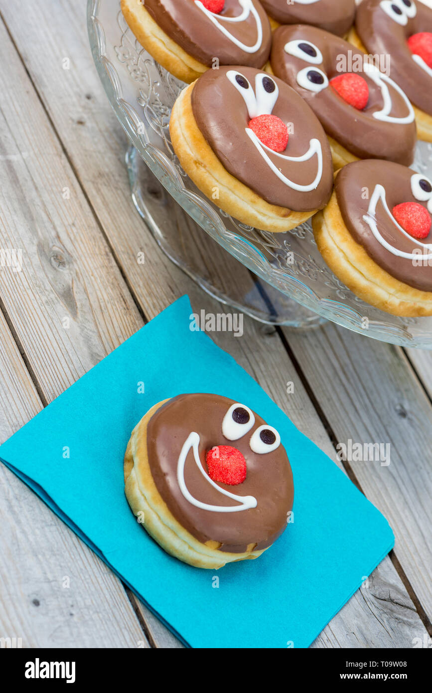 chocolate glazed donuts, with smiling faces. shallow depth of field ...