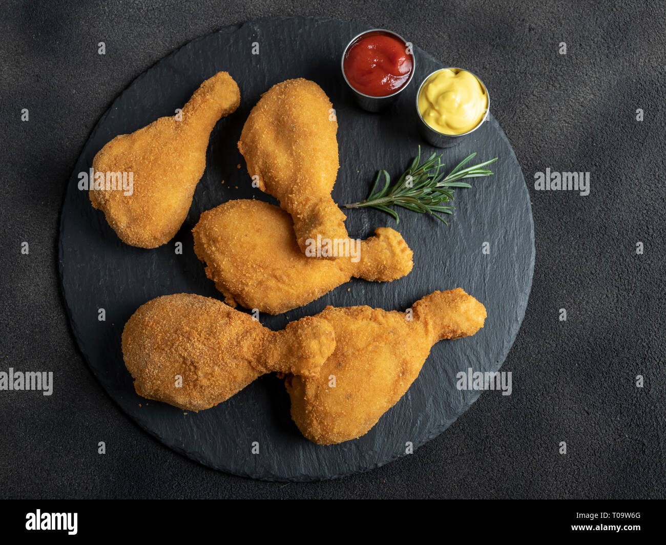 crispy fried chicken legs breaded golden color on black background ...