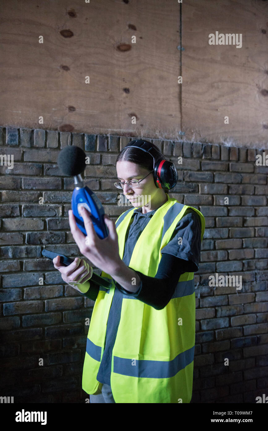 A female environmental surveyor tests for sound and noise during a ...