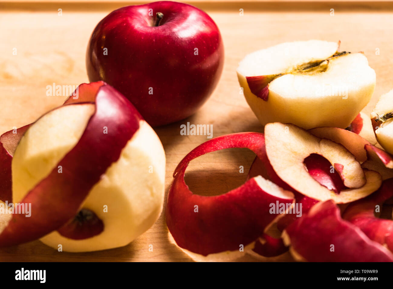 Red Apples peeled on a wood plank. Twisted peels Stock Photo - Alamy