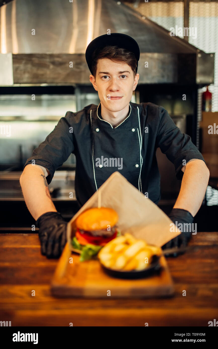 Chef in gloves and uniform cuts juicy steak piece. Fresh beefsteak ...