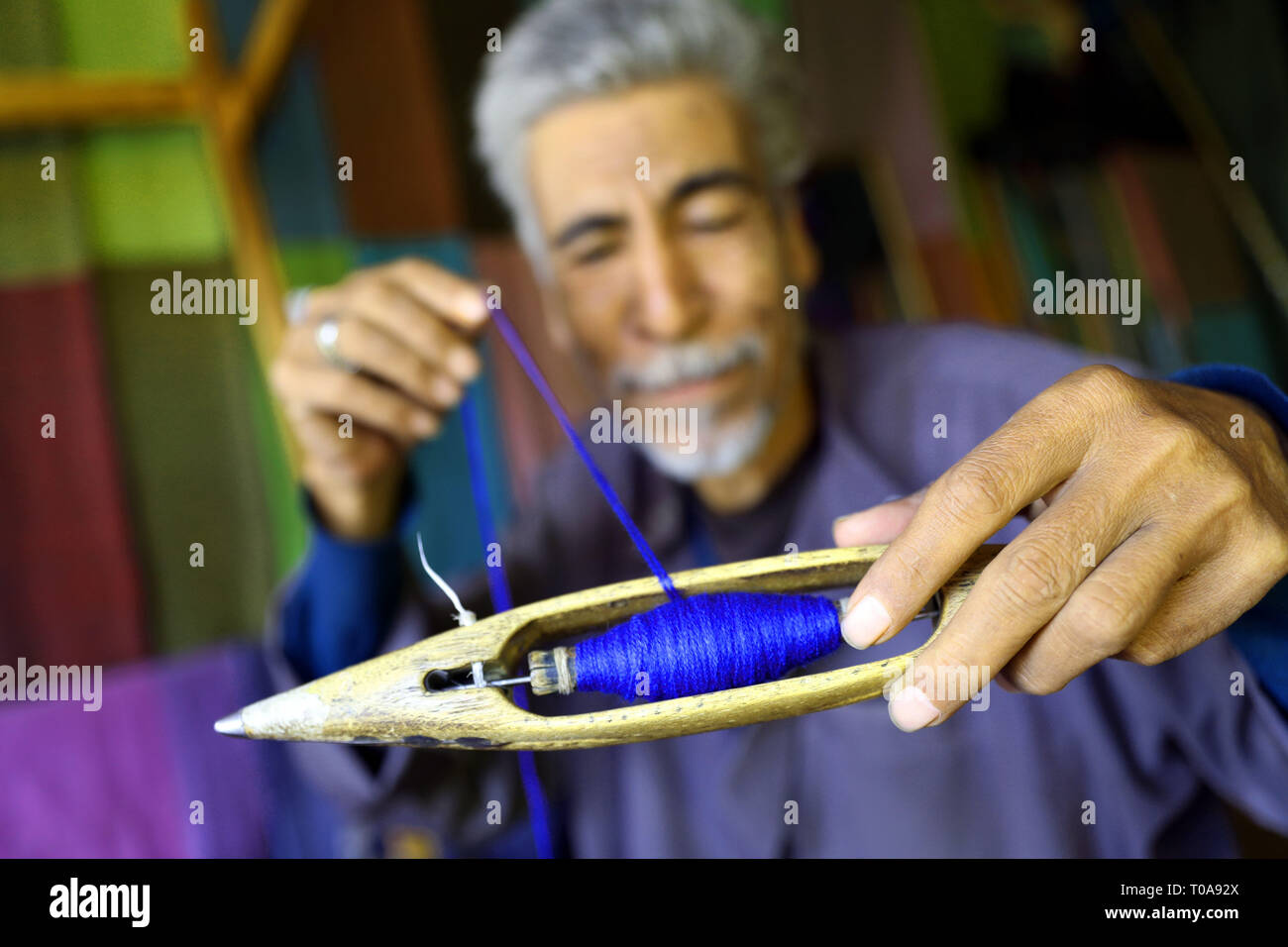Aswan, Egypt. 17th Mar, 2019. An Egyptian man displays textile weaving ...
