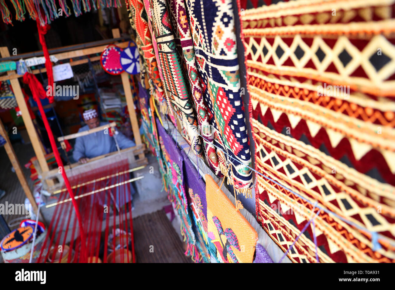 Aswan, Egypt. 17th Mar, 2019. An Egyptian man displays textile weaving ...