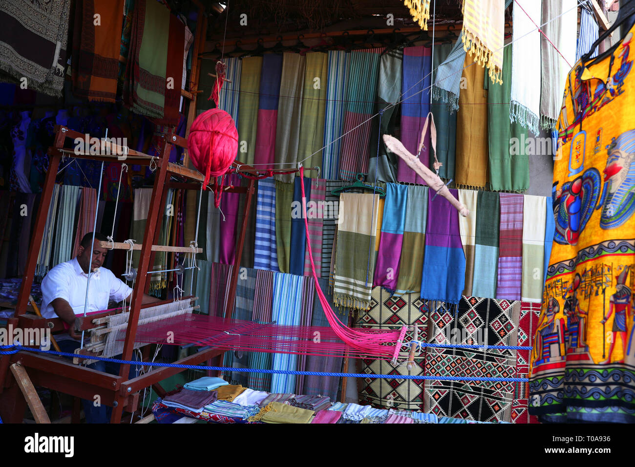 Aswan, Egypt. 17th Mar, 2019. An Egyptian man displays textile weaving ...