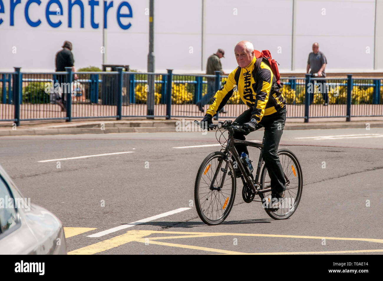 Mature cyclist on main road Stock Photo - Alamy