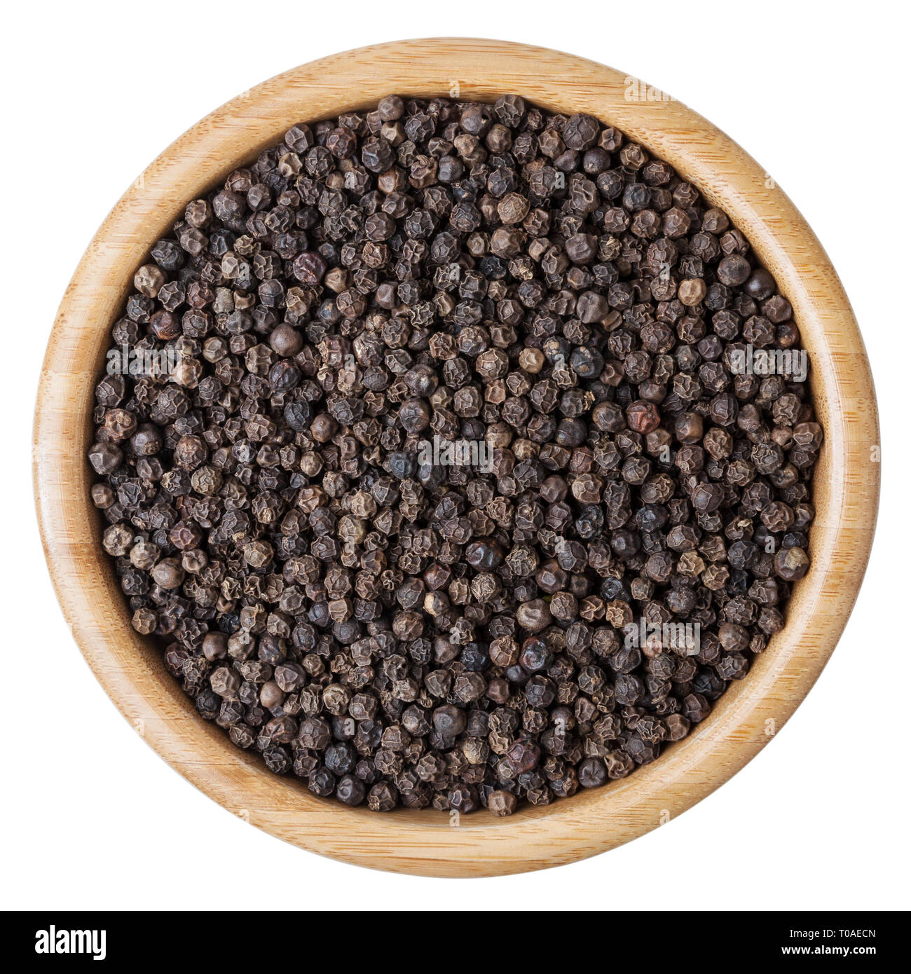 Black pepper corns in wooden bowl isolated on white background with ...