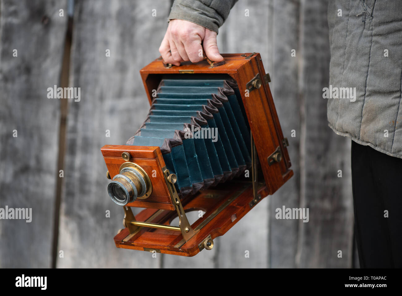 Photographer holds old large format studio camera, 5x7 inches. Concept ...