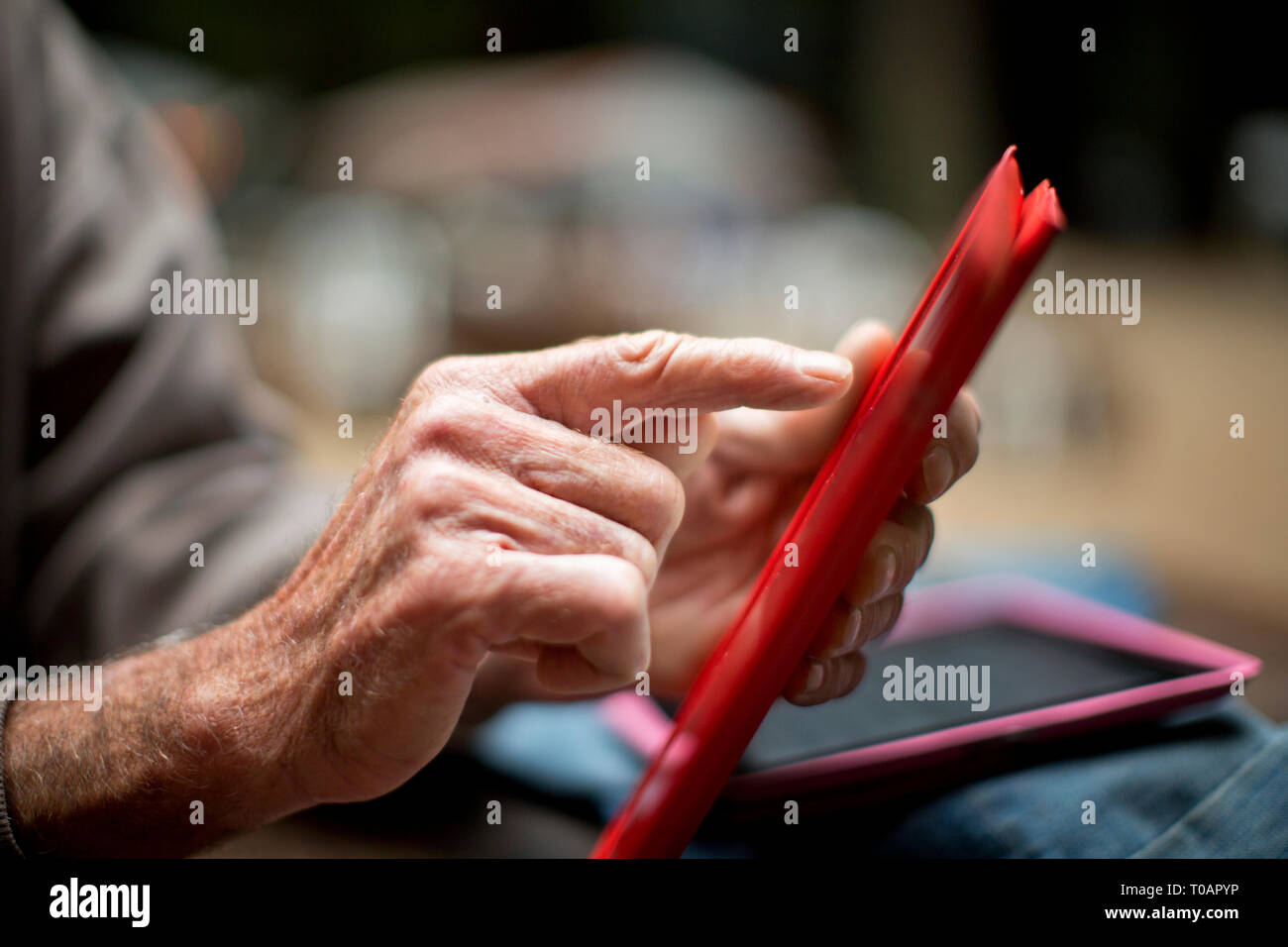 Old hands using tablet close hi-res stock photography and images - Alamy