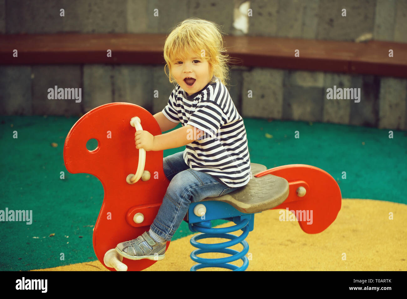 Cute happy baby boy riding red spring rider Stock Photo - Alamy