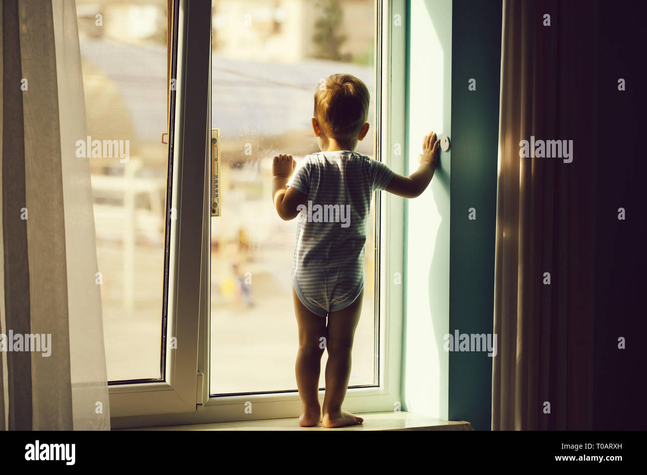 Baby boy on window sill Stock Photo - Alamy