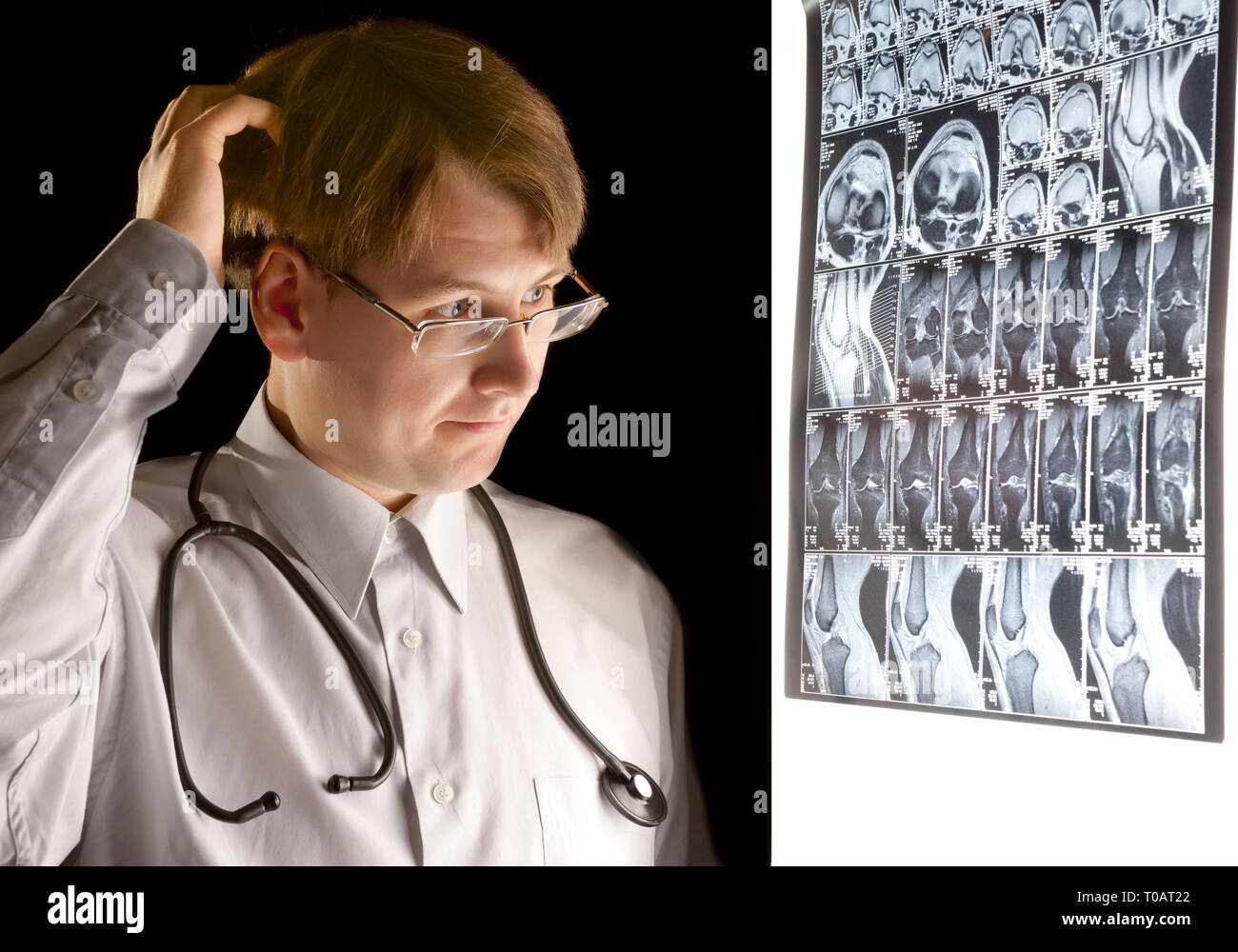Puzzled radiologist looking at MRI in dark room Stock Photo - Alamy