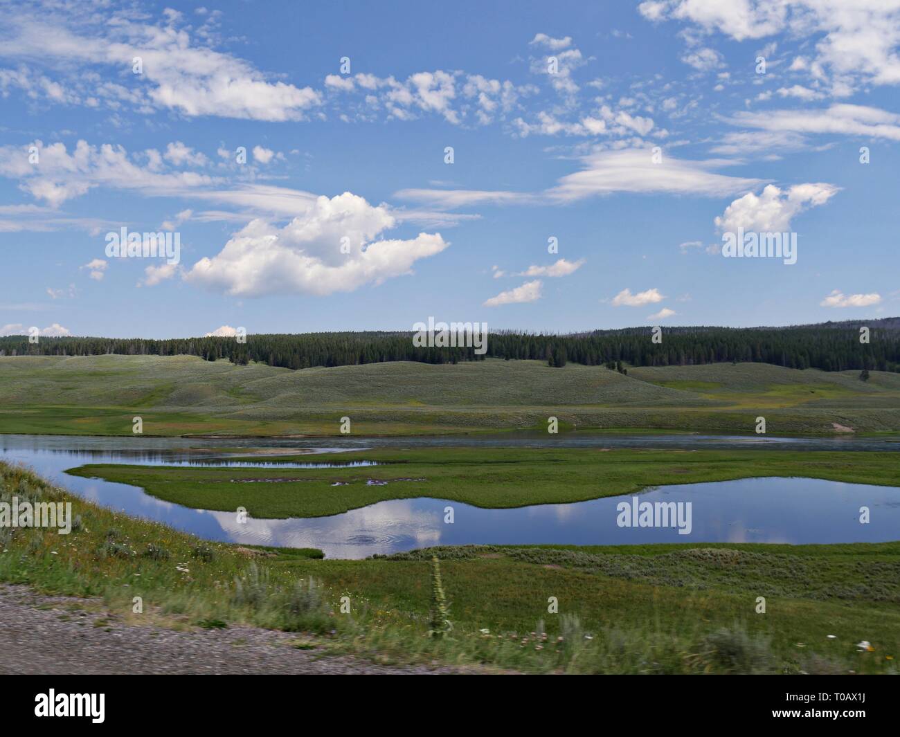 Parts of the Yellowstone River with clouds reflected in the water at ...
