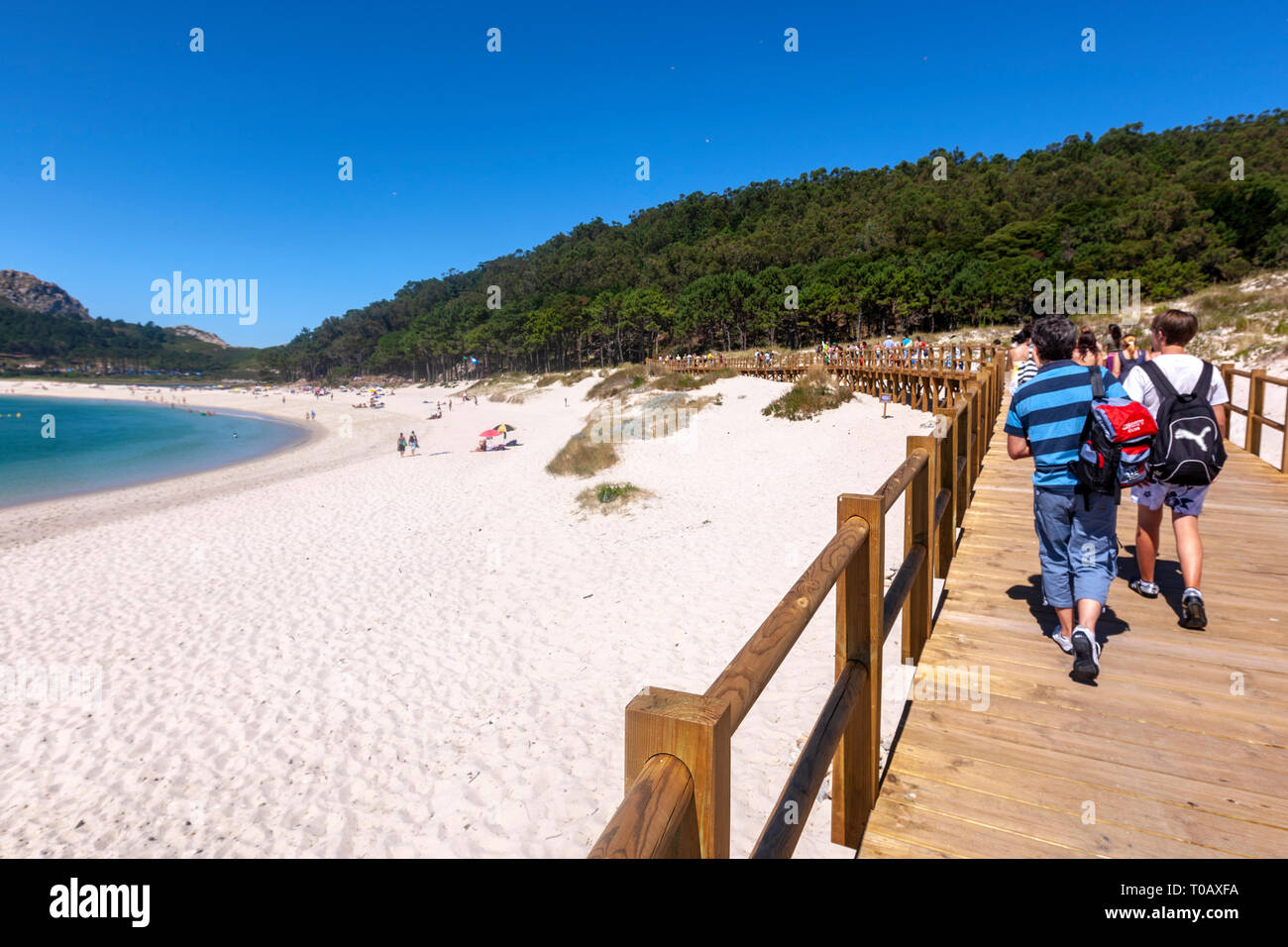 Tourist to Playa de Rodas, picturesque crescent of fine white sand ...