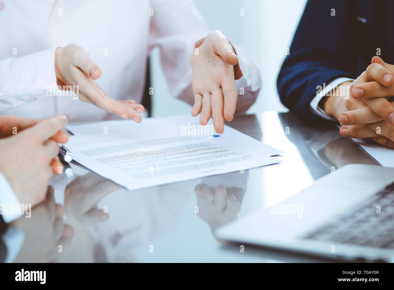 Group of business people and lawyers discussing contract papers ...