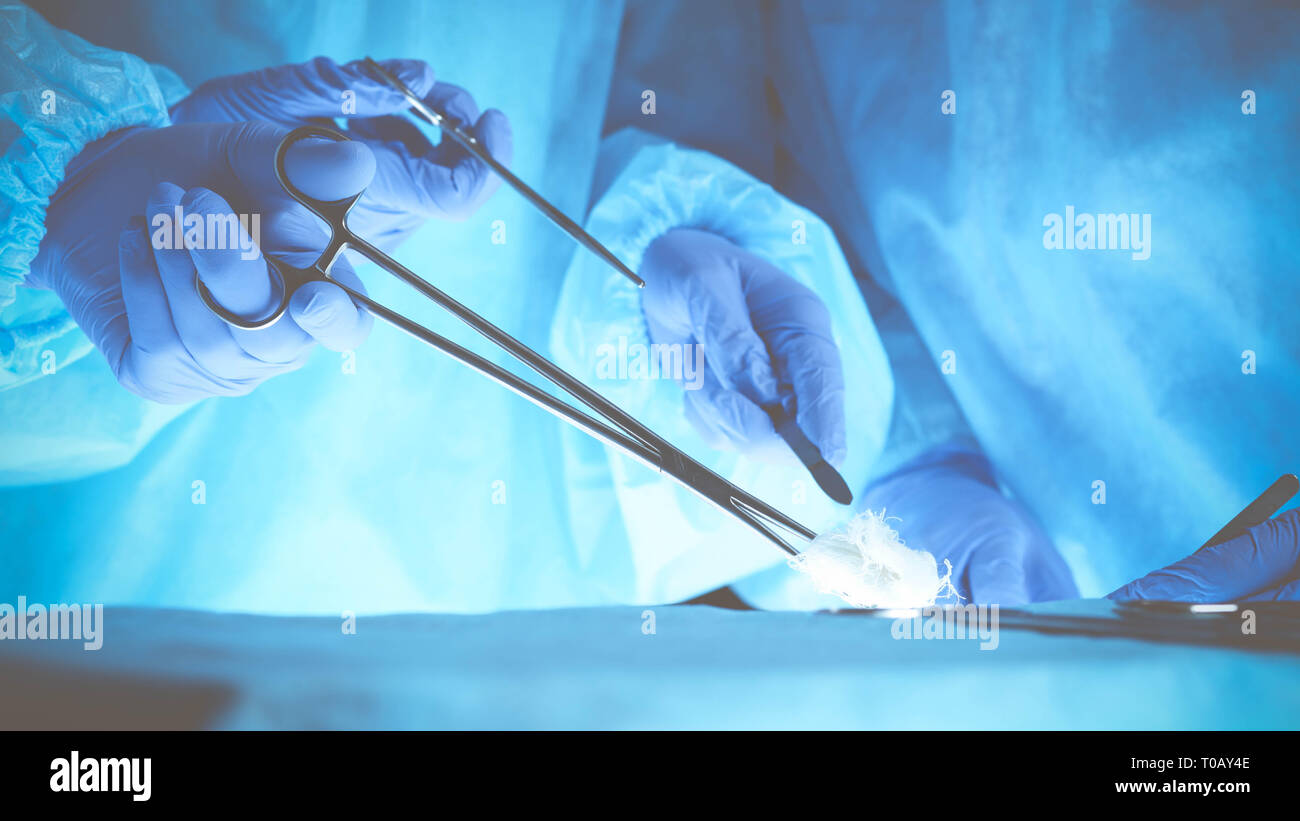 Surgeons hands holding surgical scissors and passing surgical equipment ...