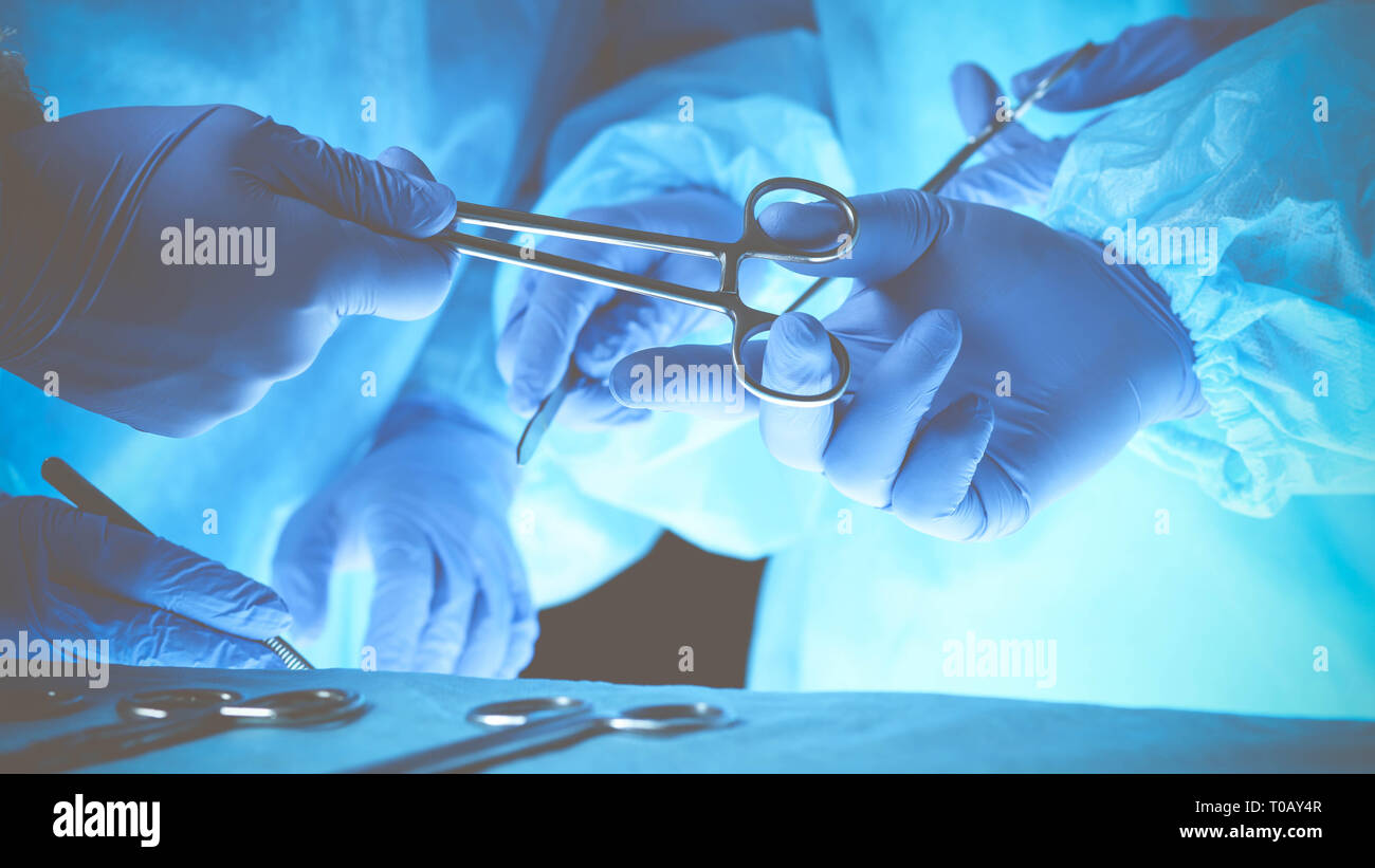 Surgeons hands holding surgical scissors and passing surgical equipment ...