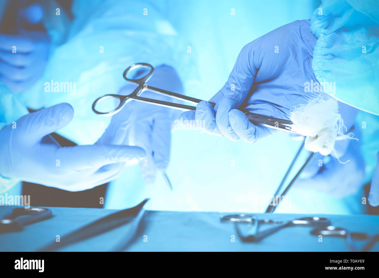 Surgeons hands holding surgical scissors and passing surgical equipment ...