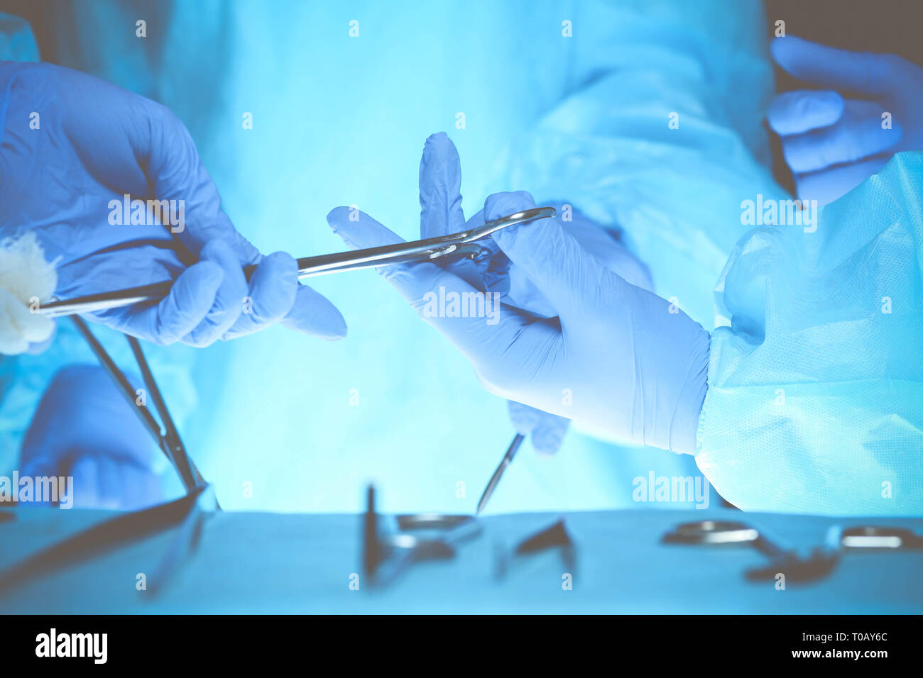 Surgeons hands holding surgical scissors and passing surgical equipment ...