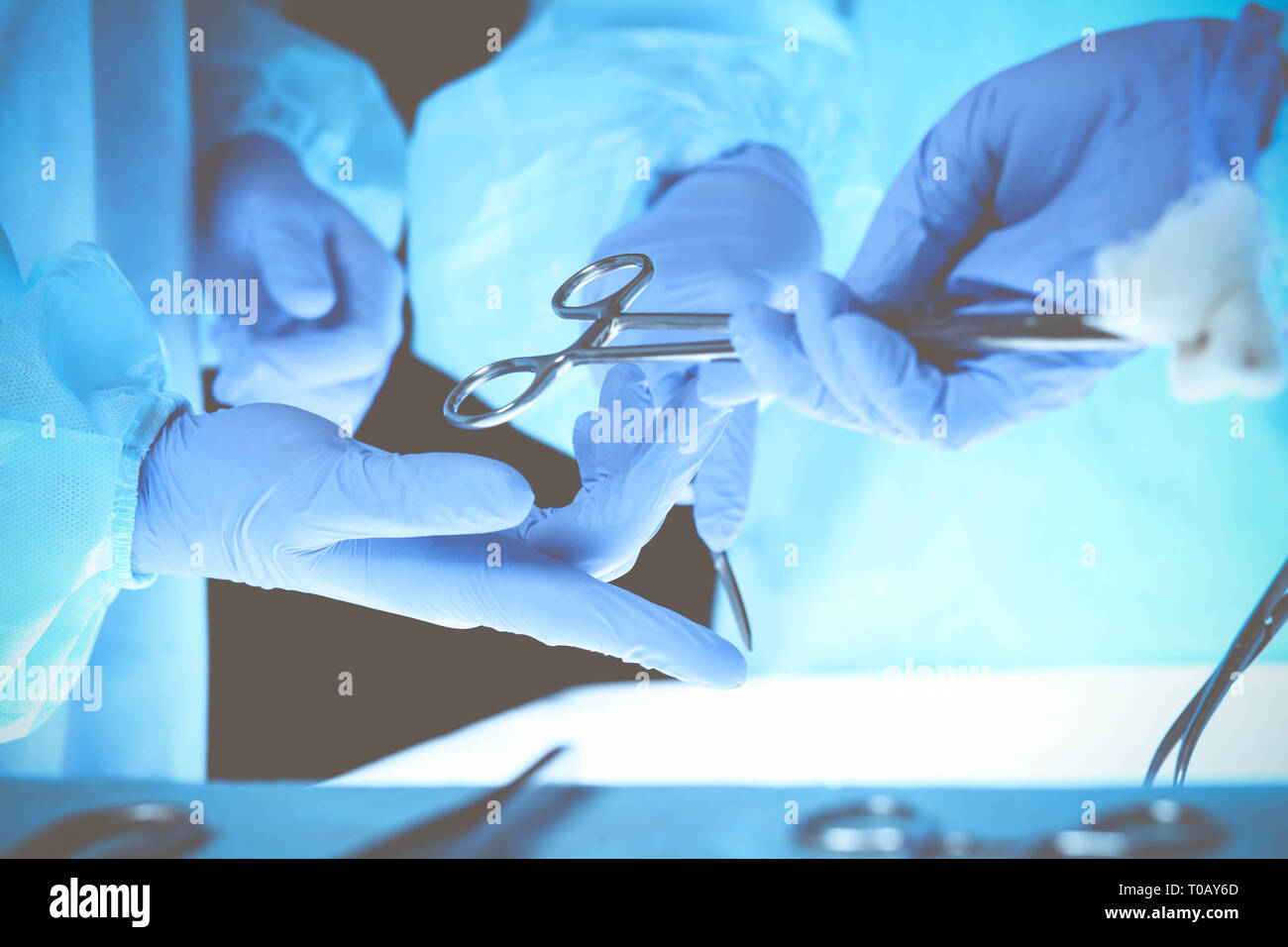 Surgeons hands holding surgical scissors and passing surgical equipment ...