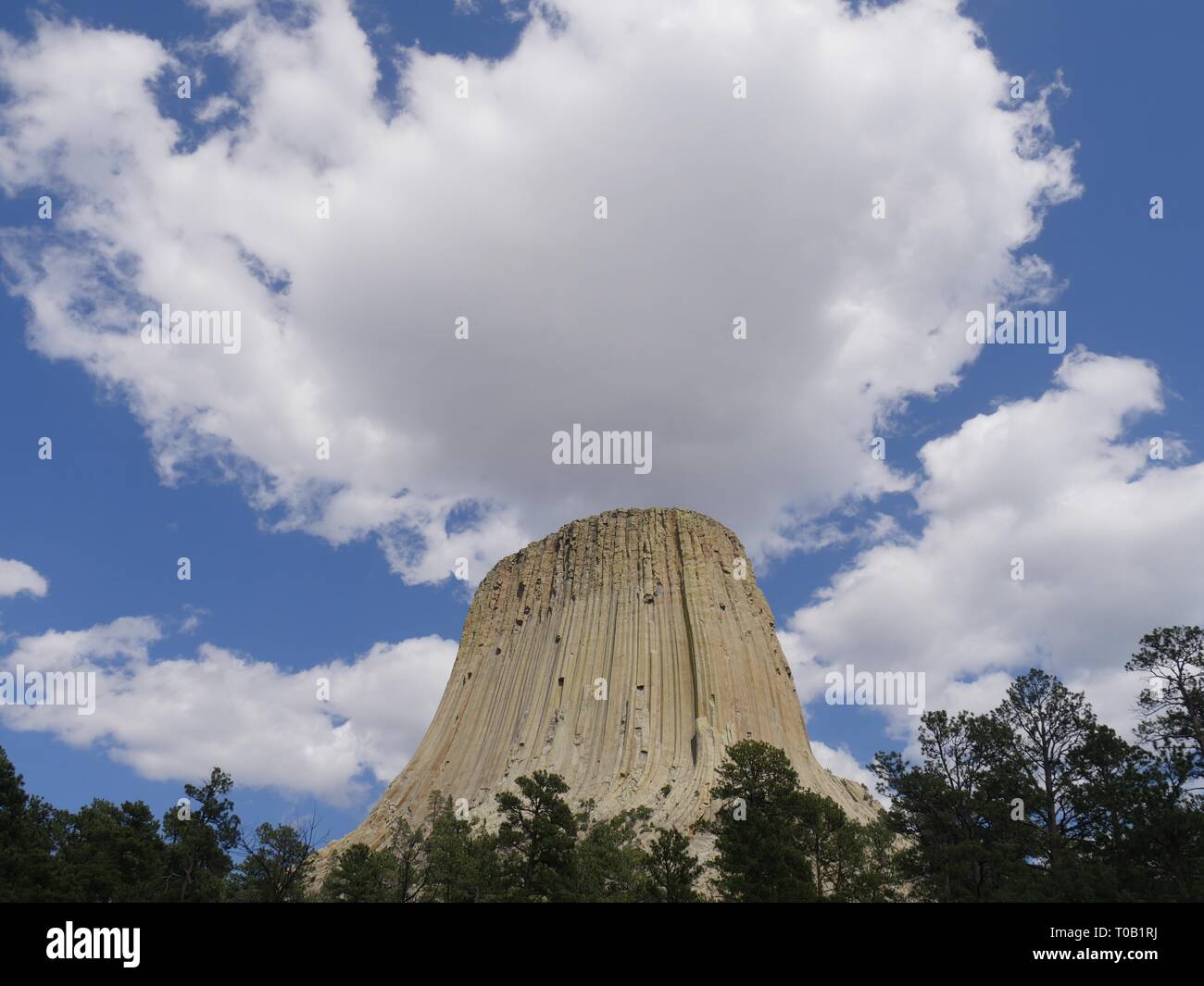 Upward shot of the Devils Tower with breathtaking clouds in the skies ...