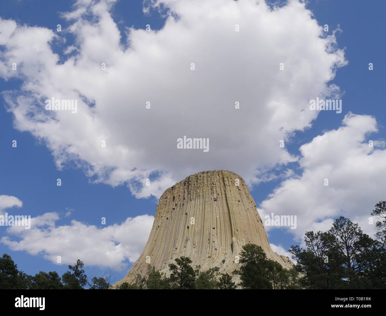 Close upward shot of the Devils Tower with breathtaking clouds in the ...