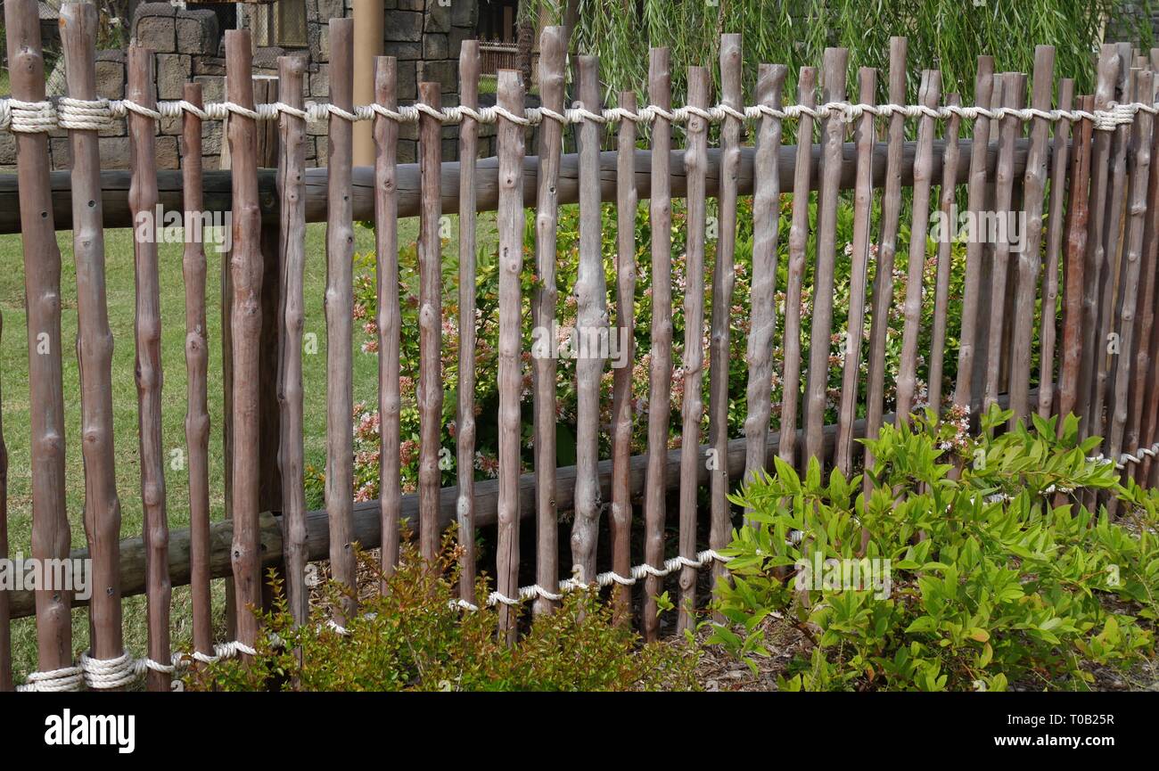 Pattern of wood posts as fence tied with ropes in a garden Stock Photo ...