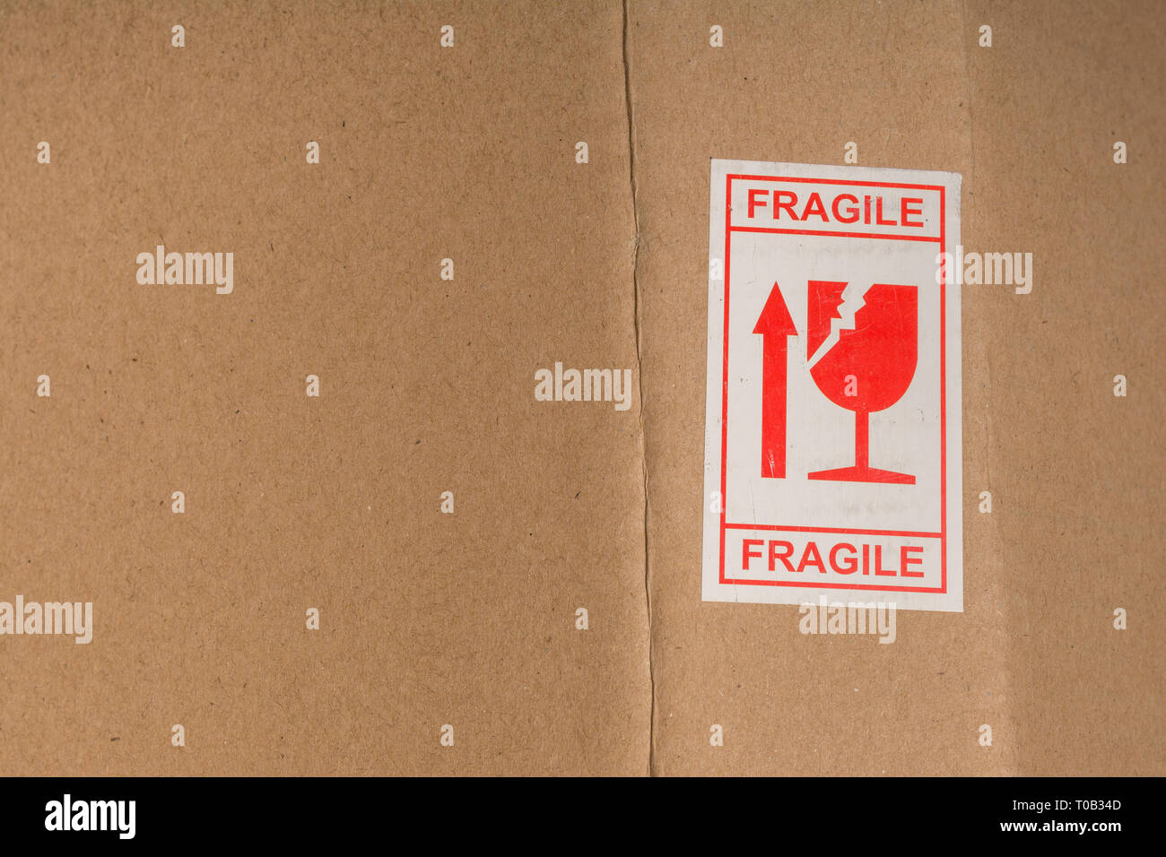 'FRAGILE' label on the side of a cardboard carton / box. Broken glass ...