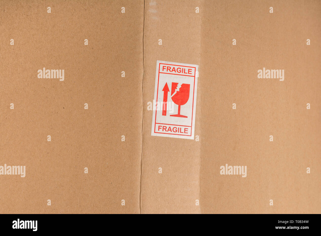 'FRAGILE' label on the side of a cardboard carton / box. Broken glass ...