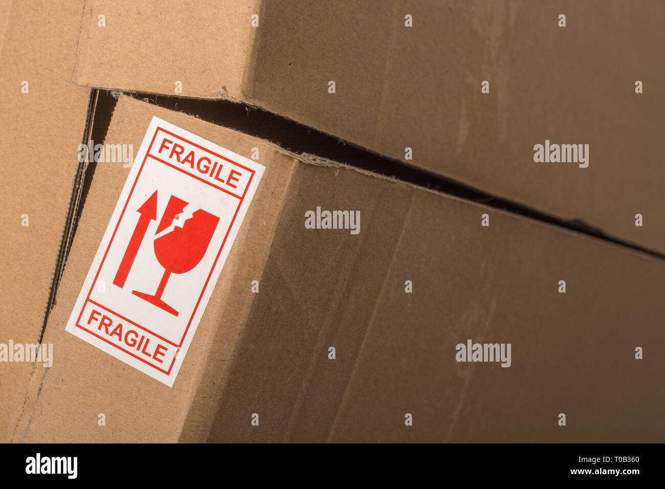 'FRAGILE' label on the side of a cardboard carton / box. Broken glass ...