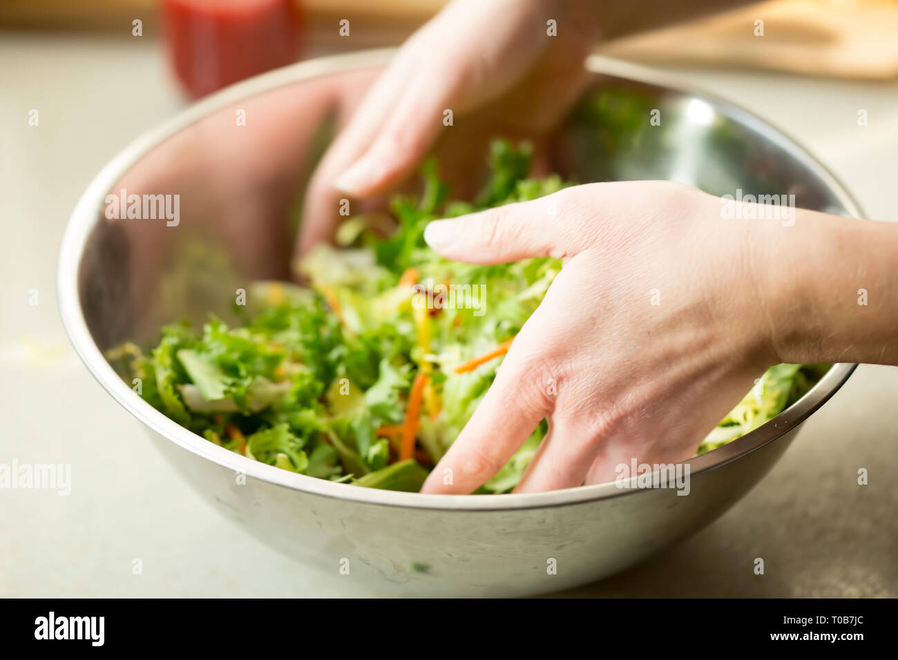 Hands mixing mixed leaves salad Stock Photo - Alamy
