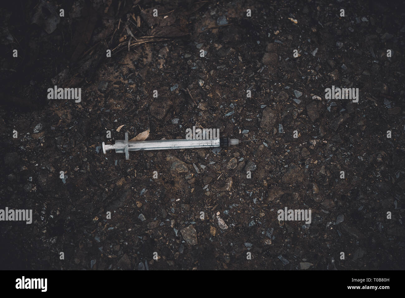 A used heroin syringe lays uncapped on a side road in a city Stock ...