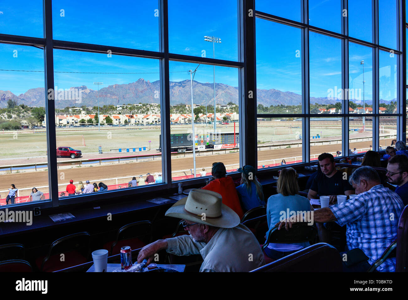 Man wearing cowboy hat and others are seated in reserved boxed seats ...