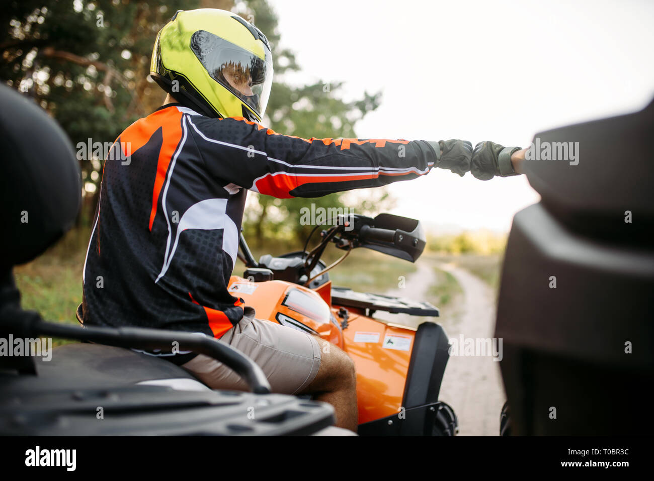 Two atv riders in helmets hits fists for good luck before extreme ...