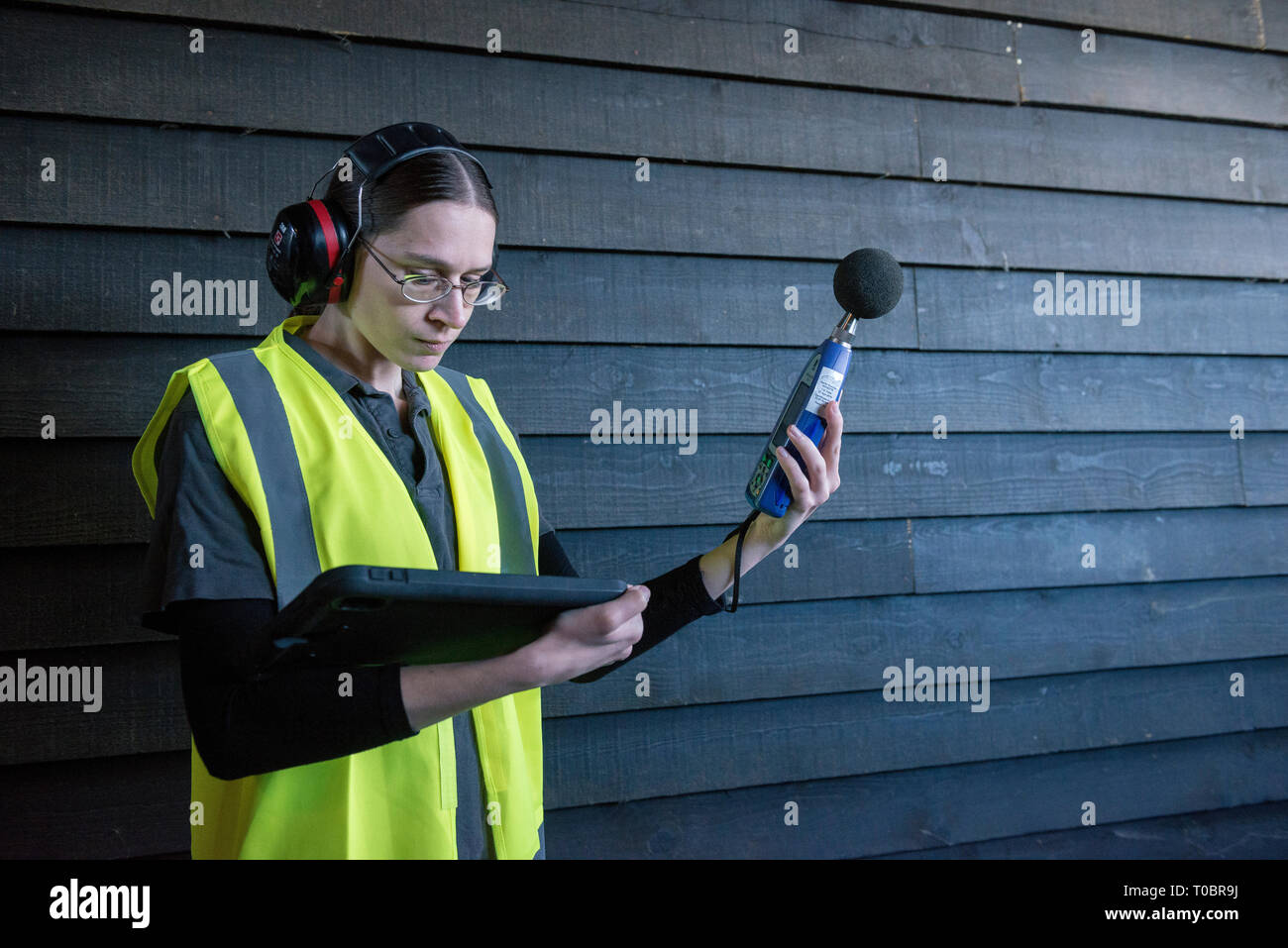 A female environmental surveyor tests for sound and noise during a ...