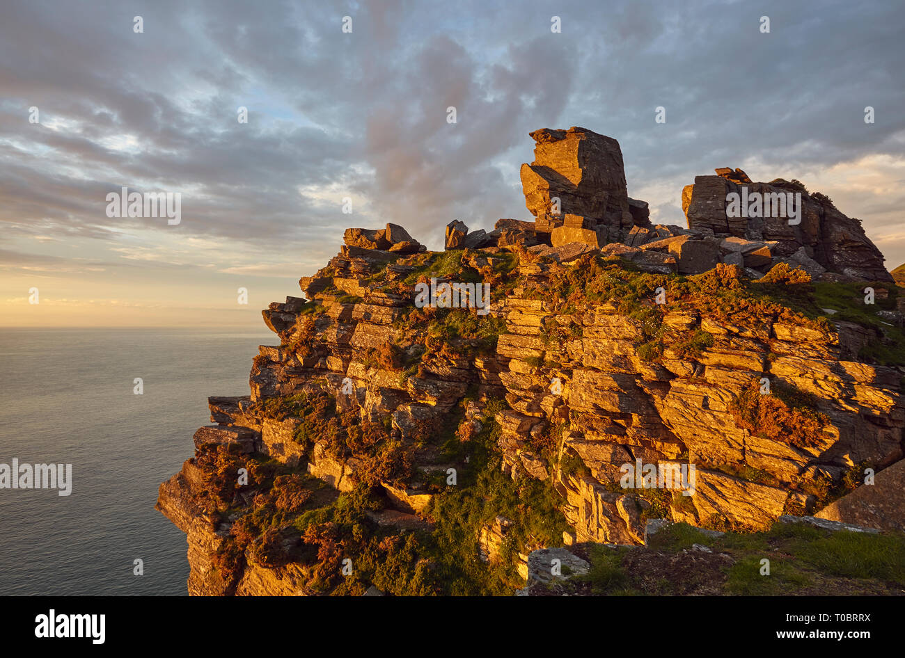 Evening sunlight illuminates coastal cliffs; at the Valley of Rocks ...