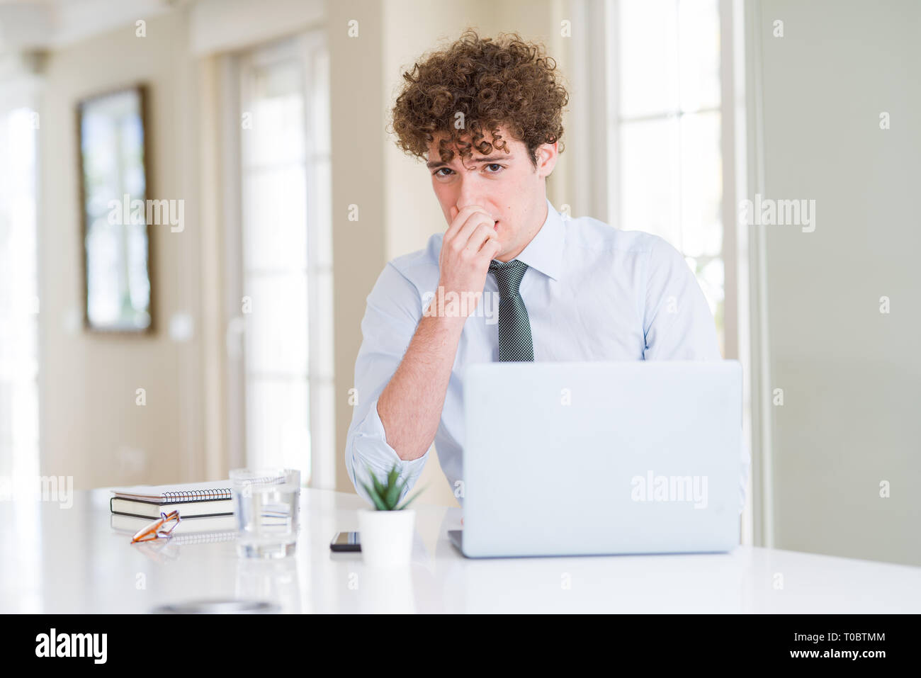 Young business man working with computer laptop at the office smelling ...