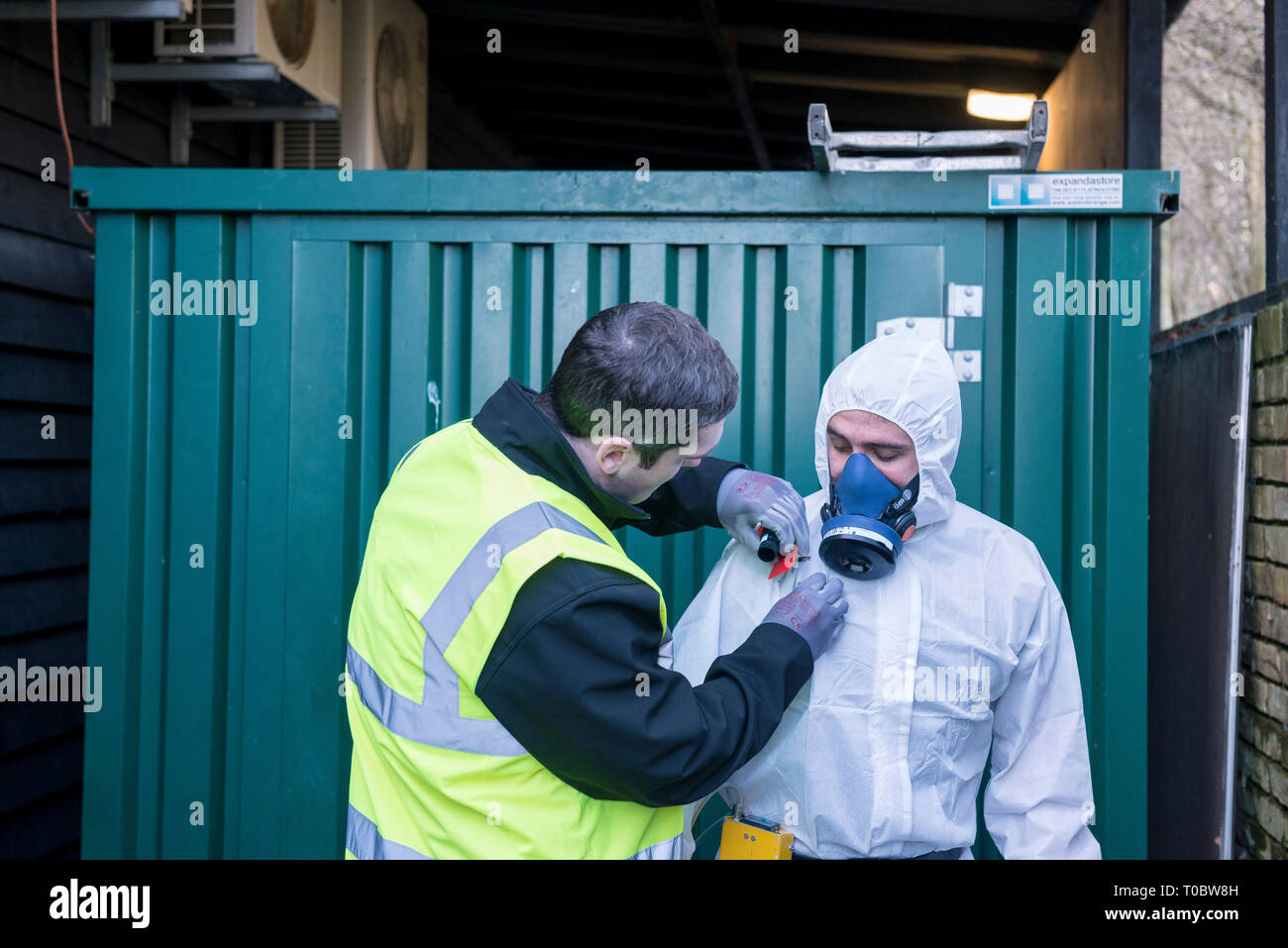 An environmental safety equipped worker in a paper body suit with ...