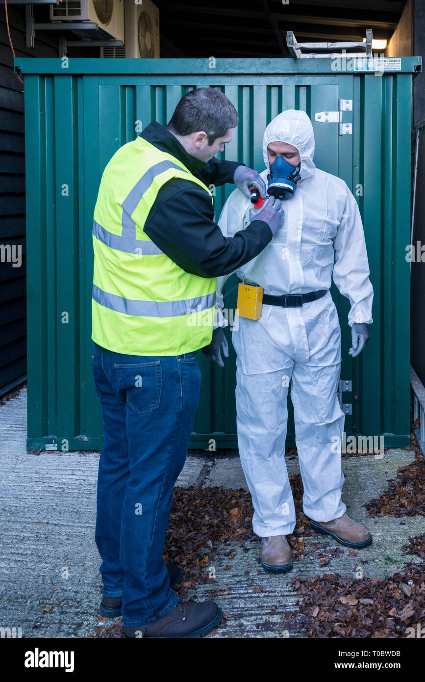An environmental safety equipped worker in a paper body suit with ...